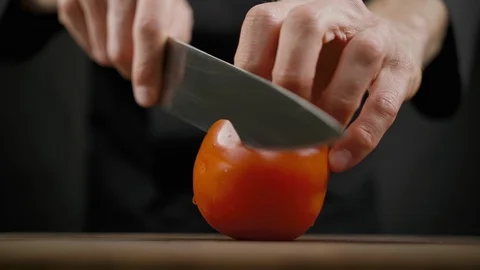 Cook chops red tomato on the wooden tabl... | Stock Video | Pond5