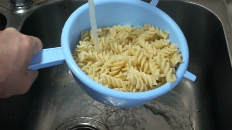 Cooked pasta in a colander is washed in ... | Stock Video | Pond5