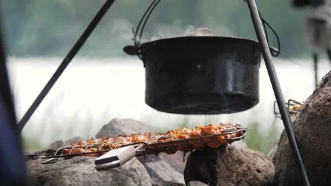 Cooking meat and boiling pot on rocks. | Stock Video | Pond5