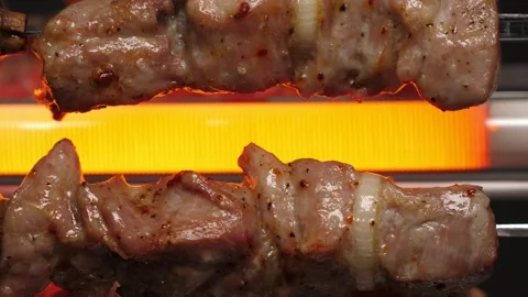 Cooking pork in electrical barbecue. Rot... | Stock Video | Pond5