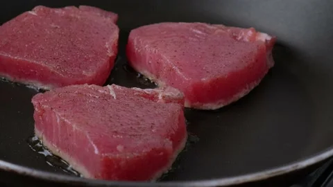 Cooking tuna steak in a frying pan. Mans... | Stock Video | Pond5