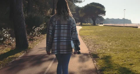 Cool girl longboarder walking on path at... | Stock Video | Pond5