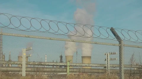 Cooling Towers with Steam behind fence t... | Stock Video | Pond5