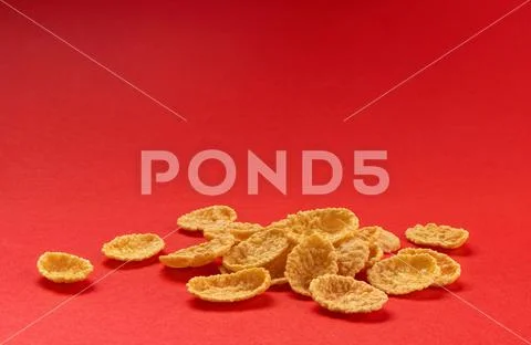 Photograph: Corn flakes isolated on red color background, full depth of ...
