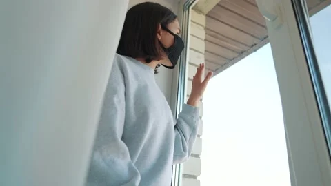 coronavirus. girl kid looks out window s... | Stock Video | Pond5