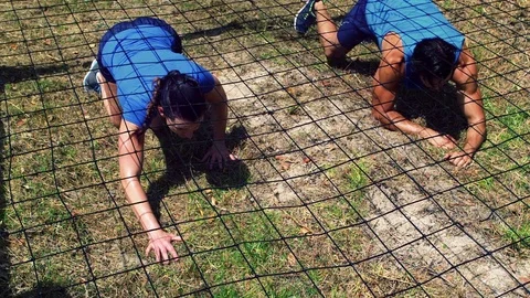 Couple crawling under the net during obs... | Stock Video | Pond5