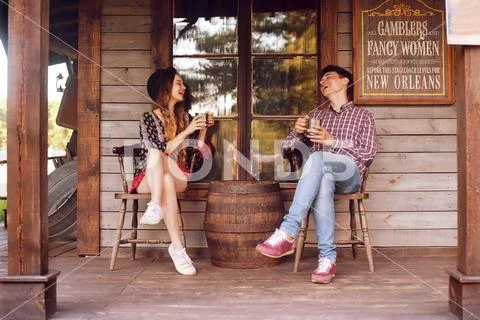 Couple drinking tea / coffee in the Wild West, in Western house. Girl ...