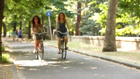 Couple of female friends riding bikes on... | Stock Video | Pond5