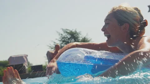 Couple With Man Splashing Woman Floating... | Stock Video | Pond5