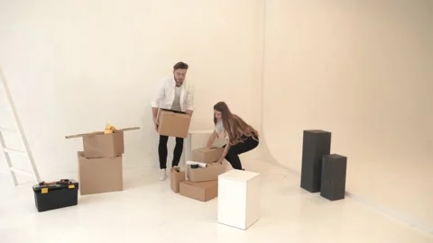 Couple packing staff in boxes while home... | Stock Video | Pond5