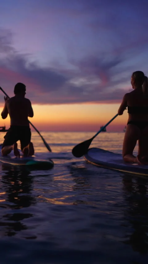 Couple paddle surfing on a beautiful bea... | Stock Video | Pond5