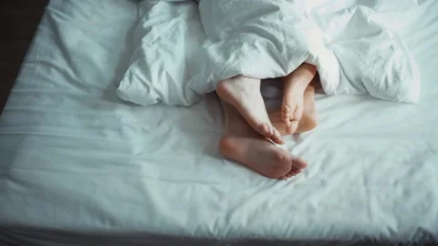 Couple petting in bed. Only feet in fram... | Stock Video | Pond5