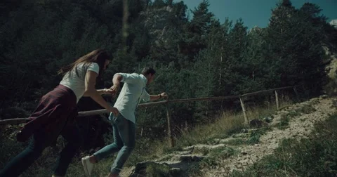 A couple run hold hands towards a forest... | Stock Video | Pond5