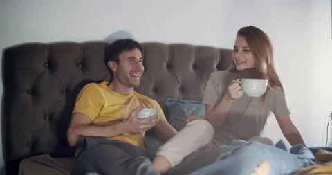 a couple serving tea in bed and watching... | Stock Video | Pond5