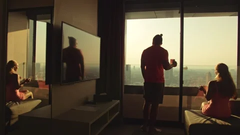 Couple watching in window on modern town... | Stock Video | Pond5