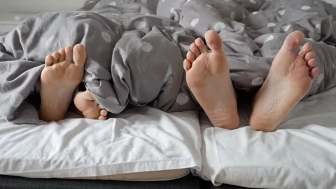 Couple's feet showing from under the bla... | Stock Video | Pond5