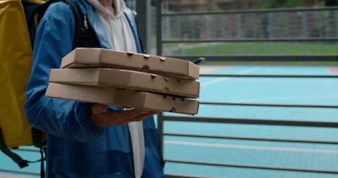 Courier carrying pizza boxes while deliv... | Stock Video | Pond5