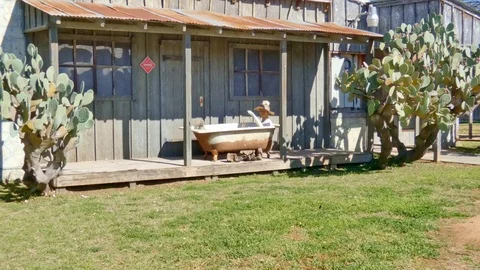 cowboy in bath tub out side old western ... | Stock Video | Pond5