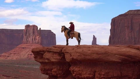 A cowboy sits on a horse on a cliff in M... | Stock Video | Pond5