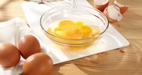 Cracked eggs. Raw egg poured into bowl. ... | Stock Video | Pond5