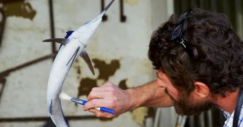 Craftsman polishing fish sculpture 4k | Stock Video | Pond5