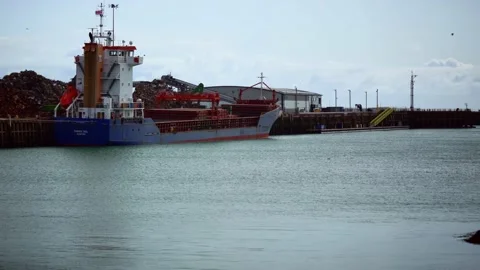 A crane loading scrap in cargo ship vess... | Stock Video | Pond5