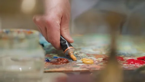 Creator squashes paint out of tube at de... | Stock Video | Pond5
