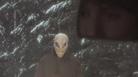 Creepy Alien Standing on Snowy Road and ... | Stock Video | Pond5