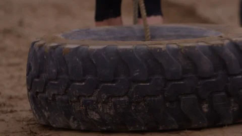 Crossfit woman dragging tire on dirt pat... | Stock Video | Pond5