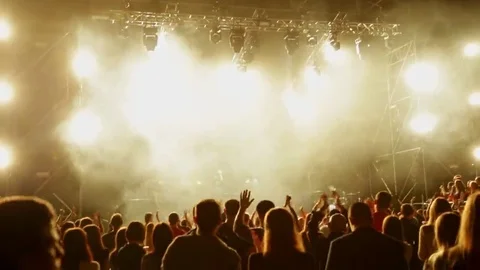 Crowd cheering in gold light at festival | Stock Video | Pond5