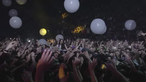 A crowd of people lit by bright lights d... | Stock Video | Pond5