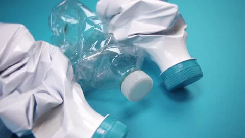 crumpled plastic bottles lie on light bl... | Stock Video | Pond5