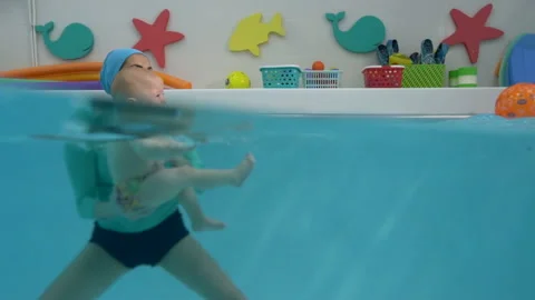 A crying baby swims in the water in the ... | Stock Video | Pond5