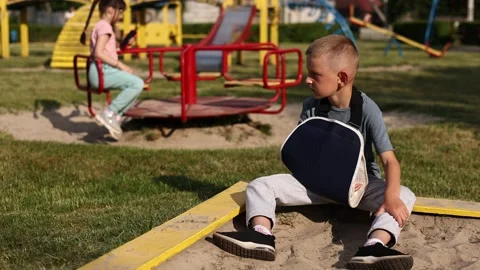 crying child with broken limb arm sits o... | Stock Video | Pond5