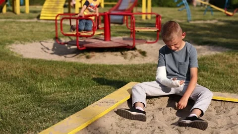 crying child with broken limb arm sits o... | Stock Video | Pond5