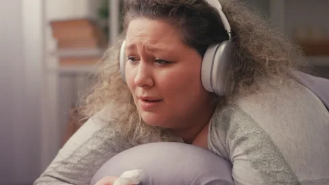 Crying sad woman in headset lying on bed... | Stock Video | Pond5