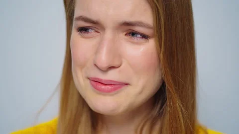 Crying woman smiling at camera on grey b... | Stock Video | Pond5