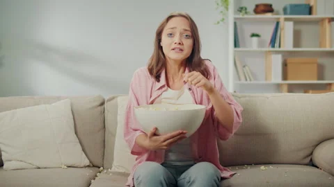 A Crying Young Woman Eating Popcorn and ... | Stock Video | Pond5