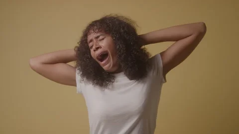 Curly-Haired Woman Yawning in Front of a... | Stock Video | Pond5