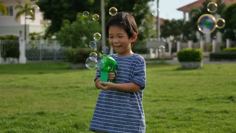 Cute Asian child Shooting Bubbles from B... | Stock Video | Pond5