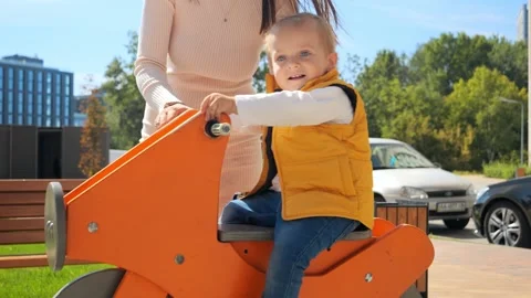 Cute baby boy riding on the spring rider... | Stock Video | Pond5