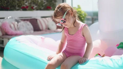 cute baby girl relaxing on rooftop patio... | Stock Video | Pond5