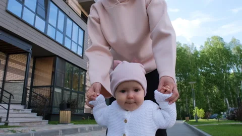 Cute baby girl takes first steps with he... | Stock Video | Pond5