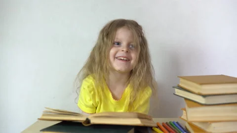 Cute beautiful little girl is reading bo... | Stock Video | Pond5