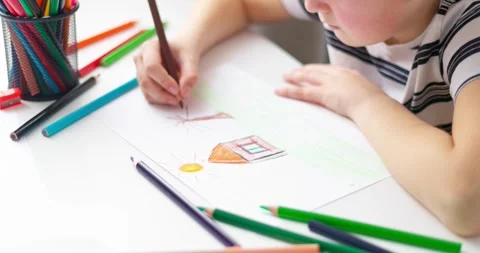 Cute boy drawing on a piece of paper wit... | Stock Video | Pond5
