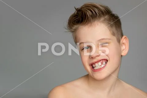 Cute boy with mohawk haircut winks with one eye. A freestanding young ...