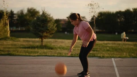 Cute female kid bouncing basketball ball | Stock Video | Pond5