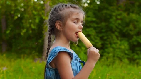 Cute girl eating popsicle ice-cream in p... | Stock Video | Pond5