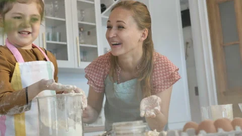 Cute girl scared of flour blown by mothe... | Stock Video | Pond5