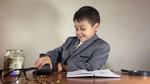 Cute kid counting coins and filling in j... | Stock Video | Pond5